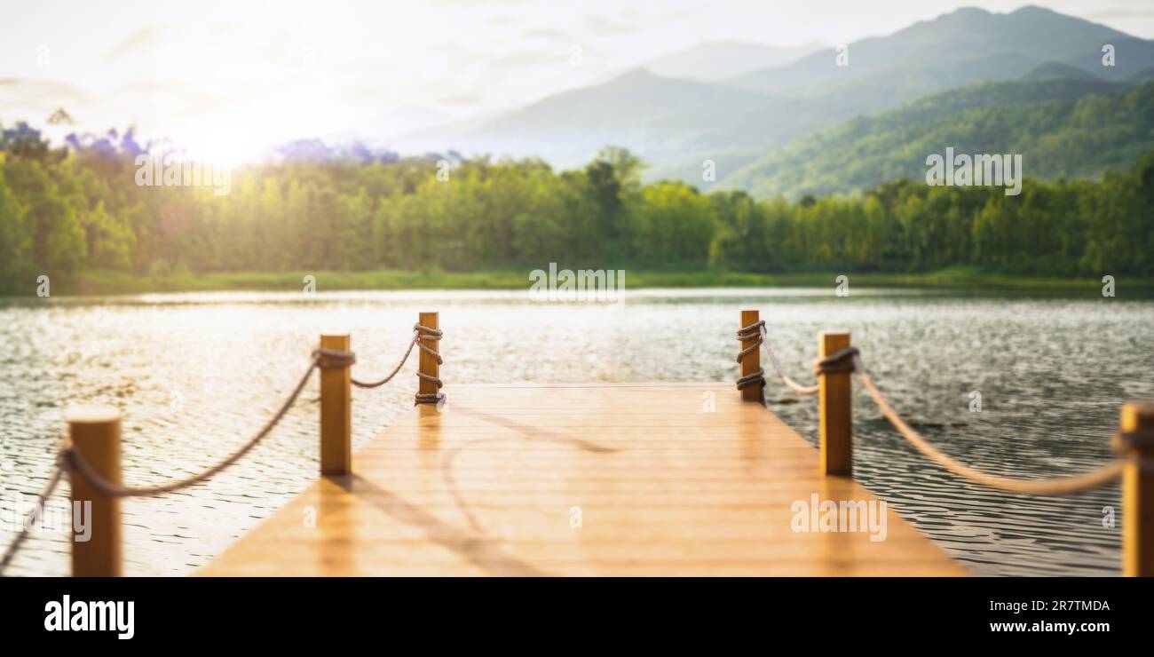 Wood pier dock quiet calm ripple lake with green forest mountain sunny ...