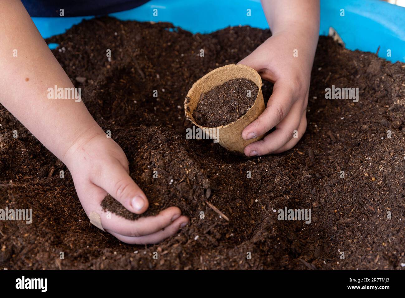Scooping potting soil into a container from a pool full of dirt Stock ...