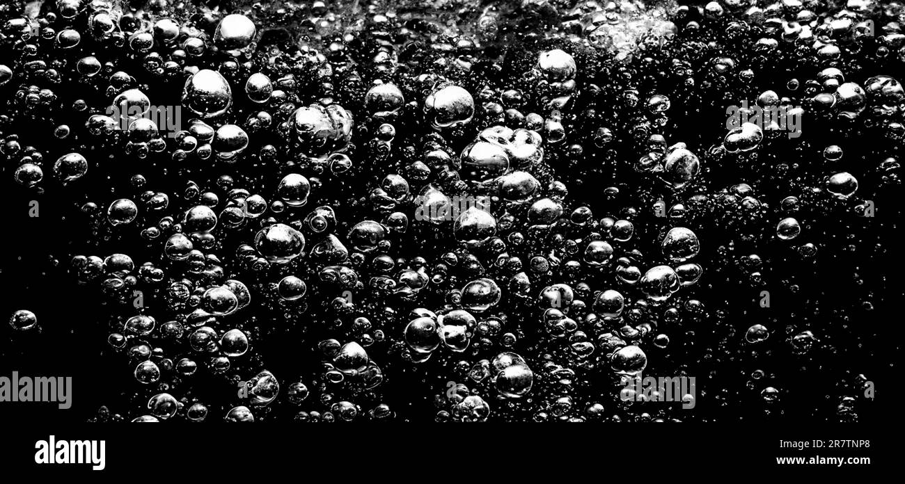 Soda water bubbles splashing underwater against black background. Cola ...