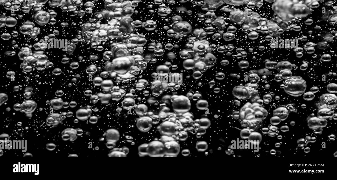 Soda water bubbles splashing underwater against black background. Cola ...