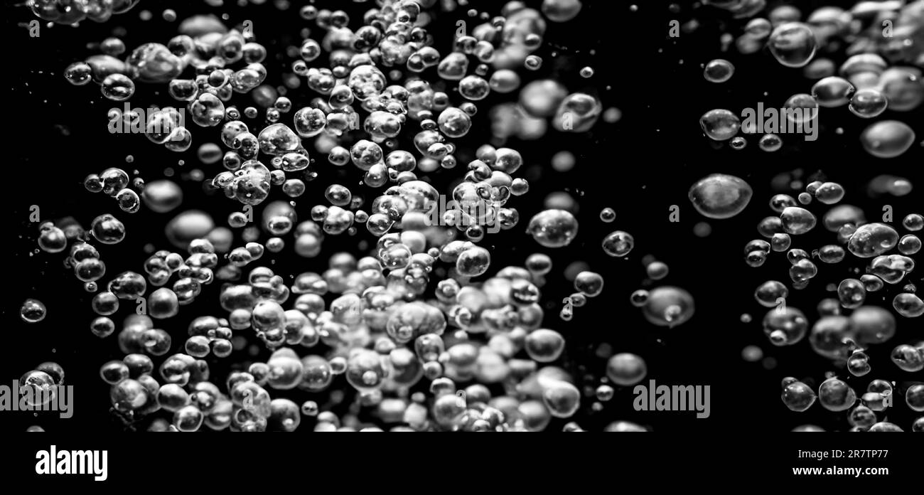 Soda water bubbles splashing underwater against black background. Cola ...
