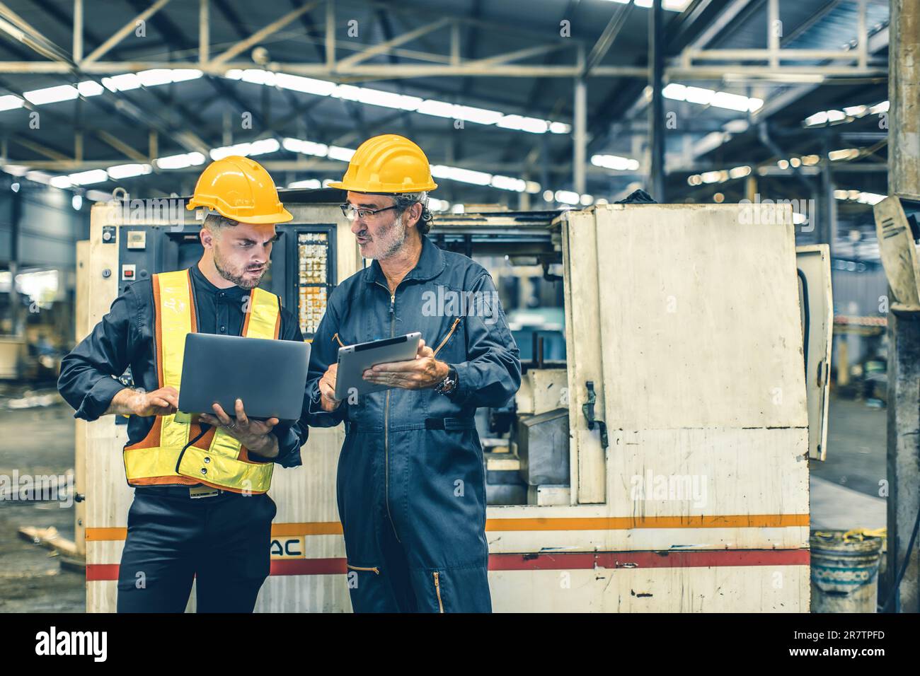 senior male worker training new young engineer employee working in ...