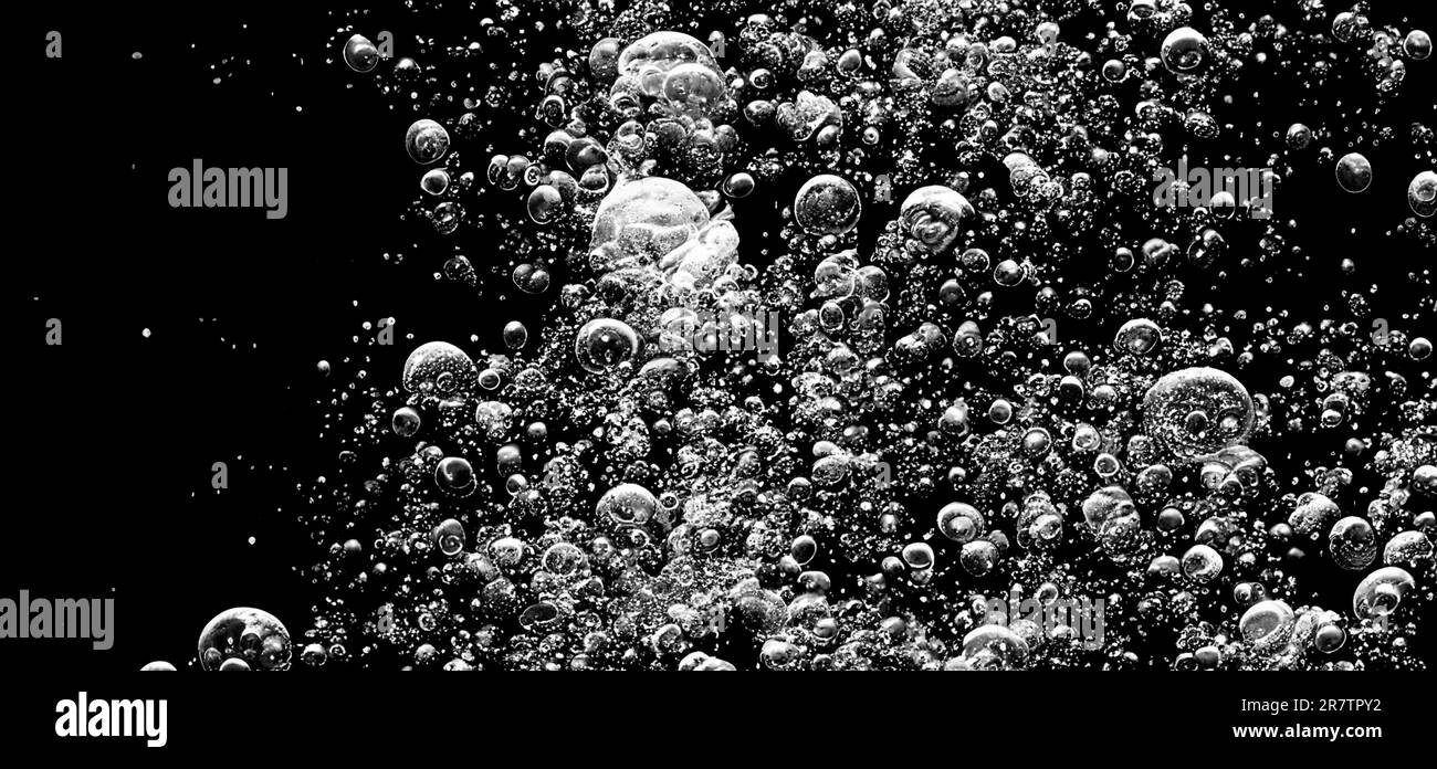 Soda water bubbles splashing underwater against black background. Cola ...