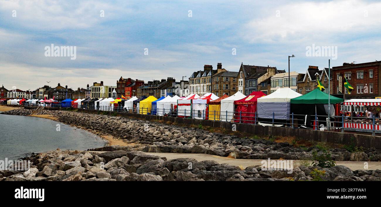 The stalls of a pop up street market are arranged with their backs to ...