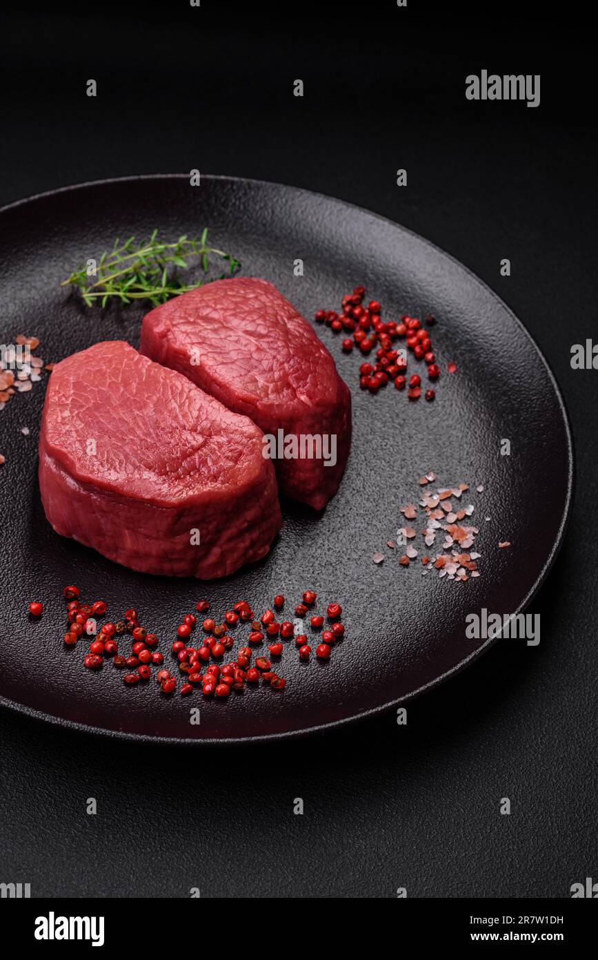Raw beef eye steak round with salt, spices and herbs prepared for ...