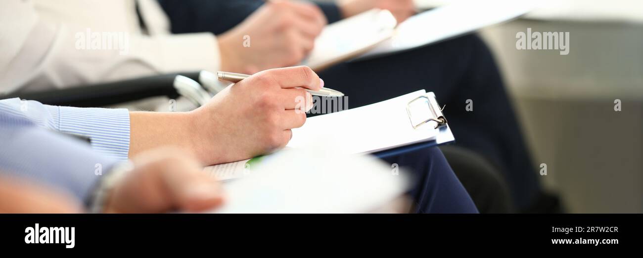 Businessmen are holding documents while taking notes at seminar Stock ...