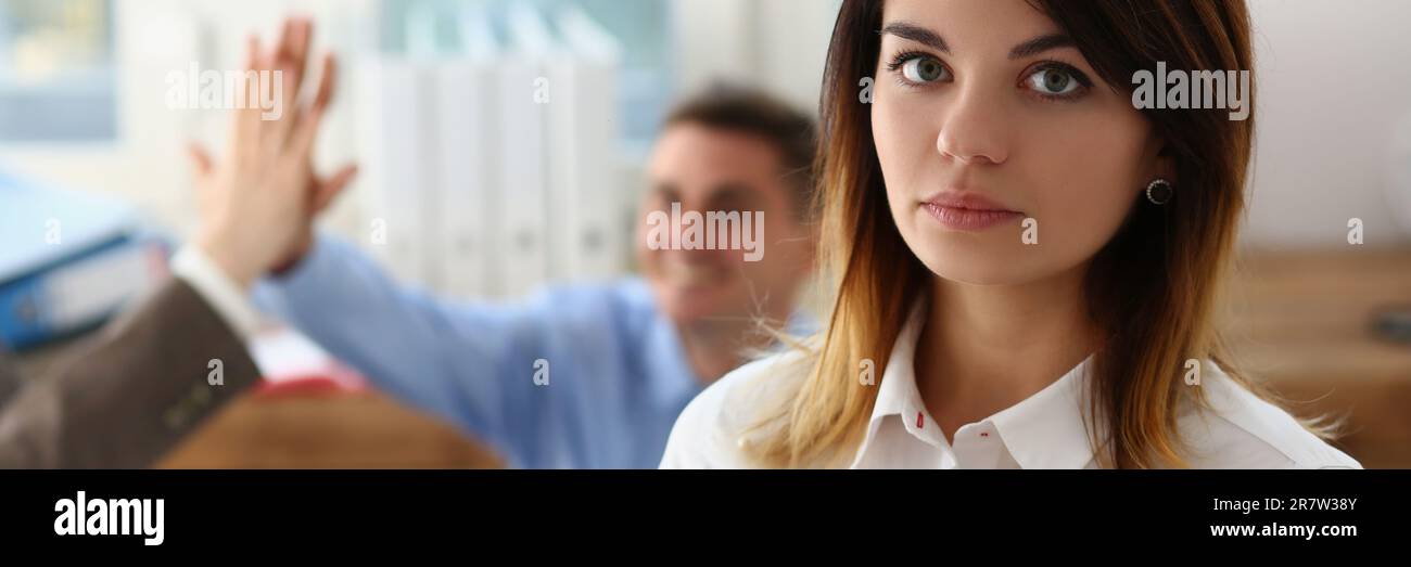 Sad dismissed woman against background of joyful colleagues partners in ...