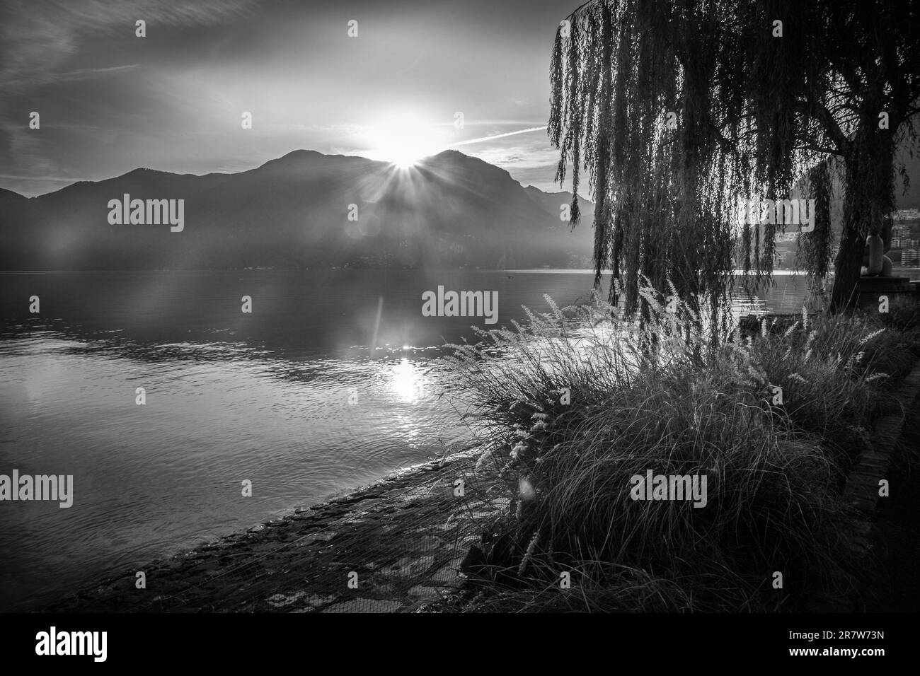 Black and white sunrise on Lugano Lake, with rising sun behind ...