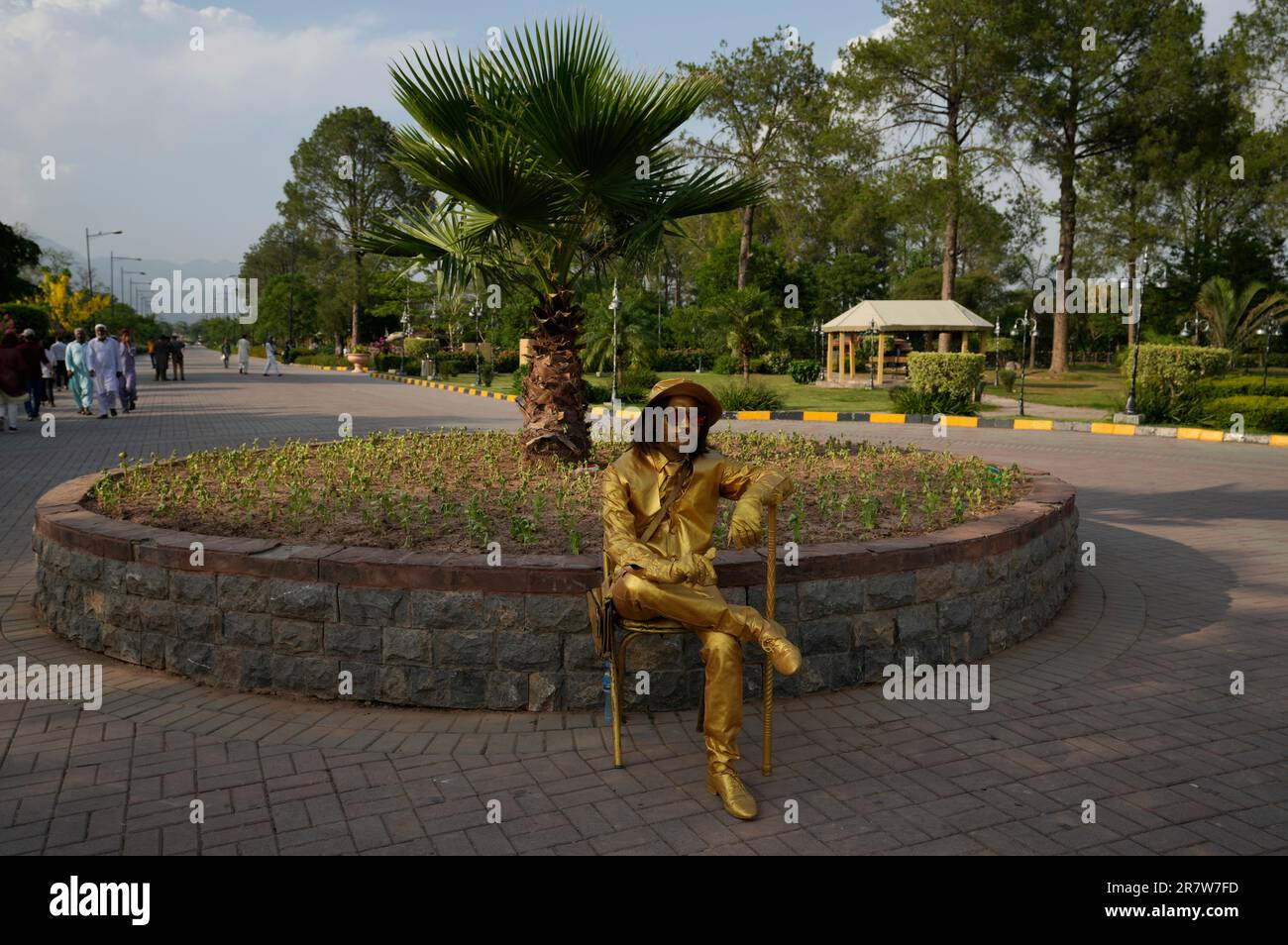A Pakistani man poses like a statue to entertain people, in Lake View ...