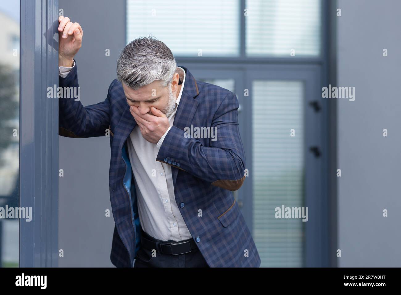 Mature gray haired boss has food poisoning, man outside office building ...