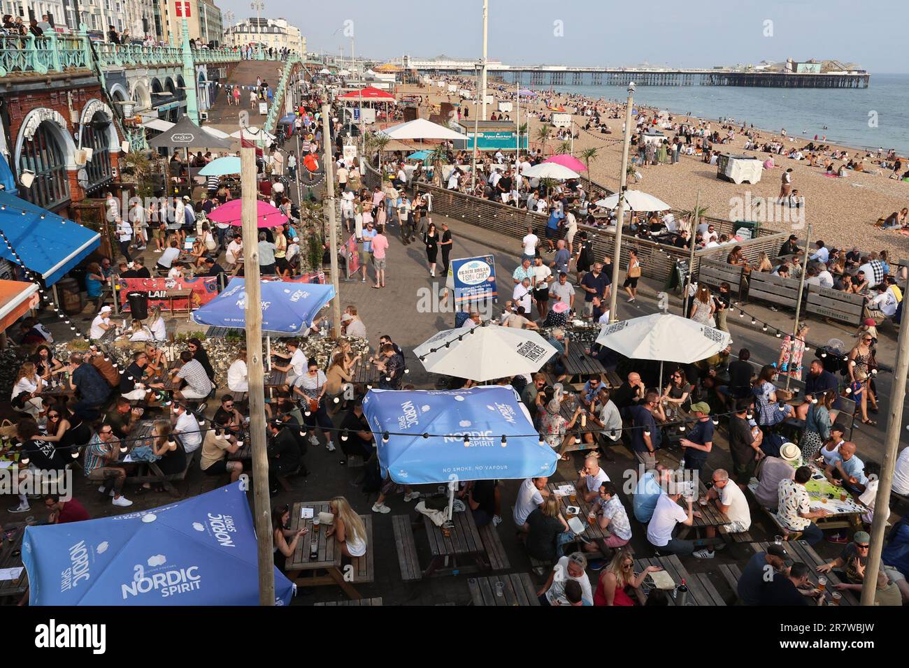Busy pubs and bars on Brighton seafront with the Palace Pier in the ...