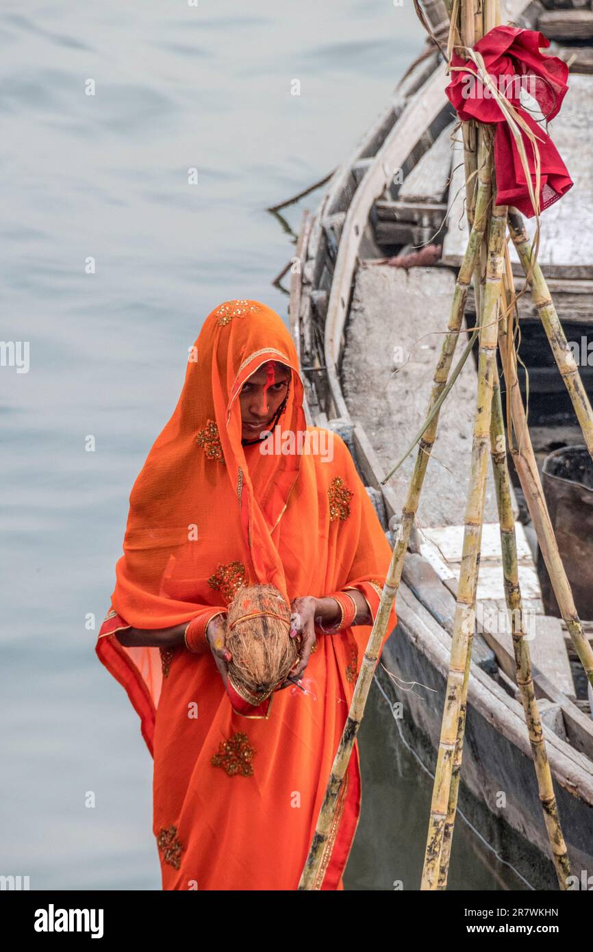 A devotee makes an offering and prays in the Ganges during Chhath Puja ...