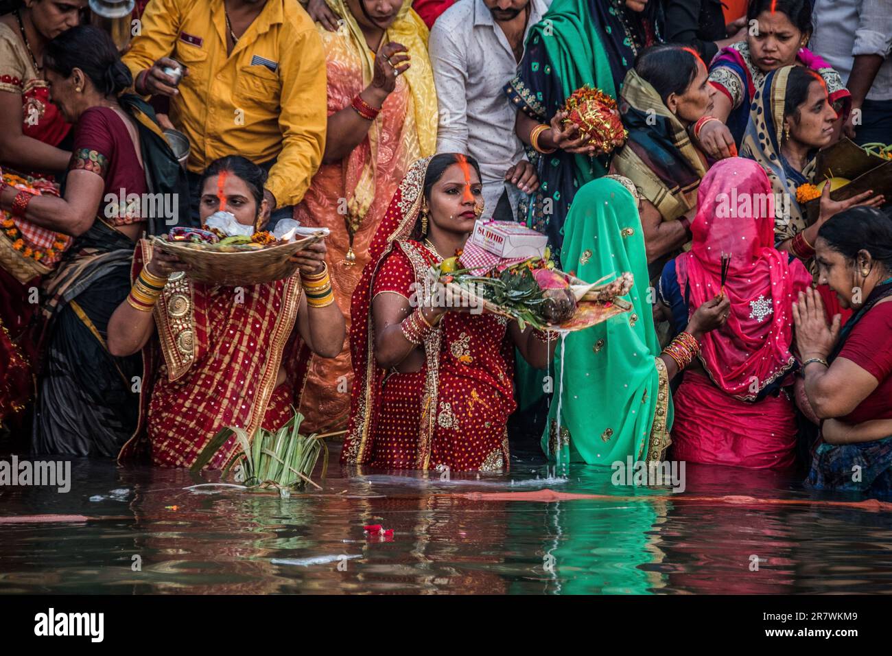 Devotees make offerings and pray in the Ganges during Chhath Puja in ...