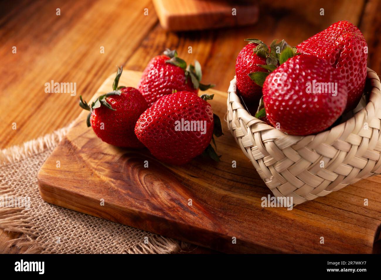 Fresh organic strawberries (fragaria) on wooden table. Also known as ...