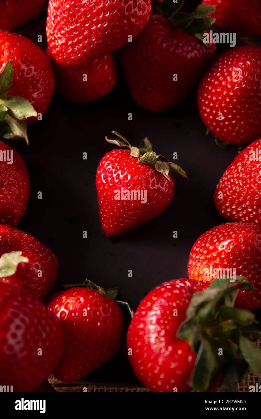 Fresh organic strawberries (fragaria) on wooden table. Also known as ...