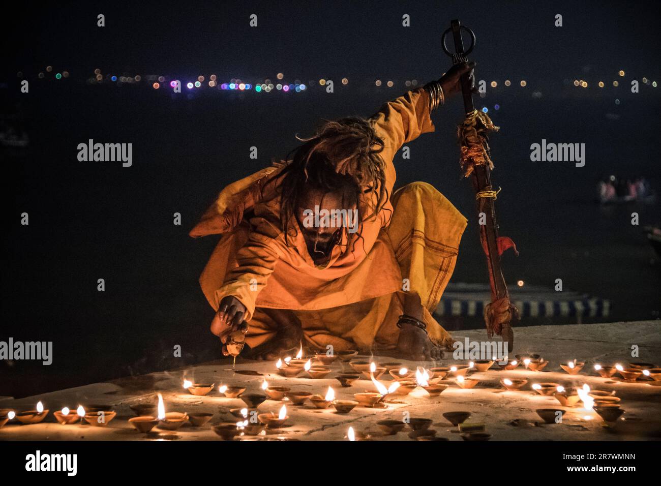 A Sadhu lights oil lamps during Dev Deepawali celebrations on the Ghats ...