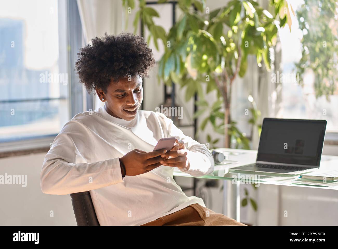 Gen z African American teenager using mobile phone at home Stock Photo ...