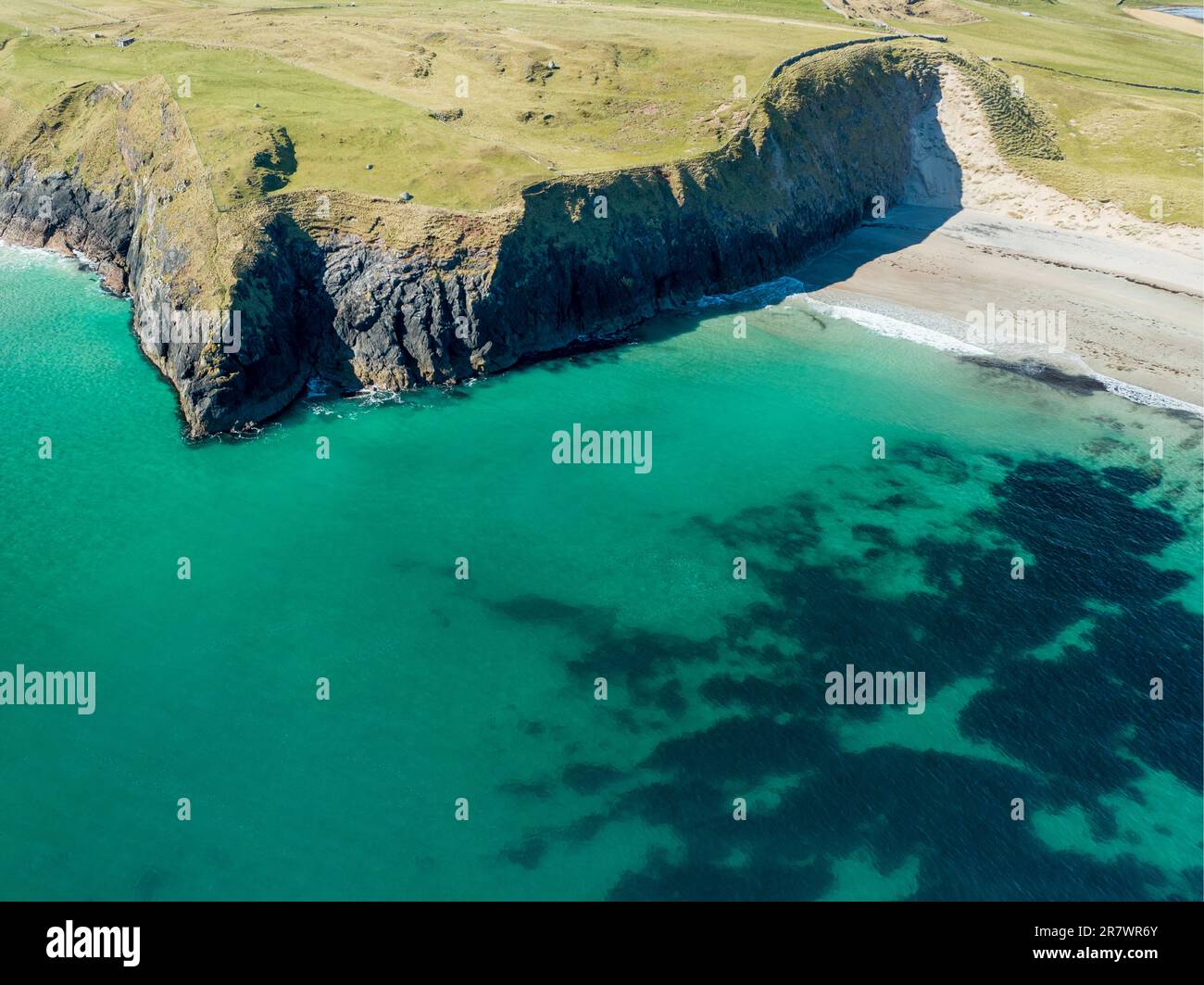 An idyllic coastal scene featuring a vivid blue and green shoreline ...