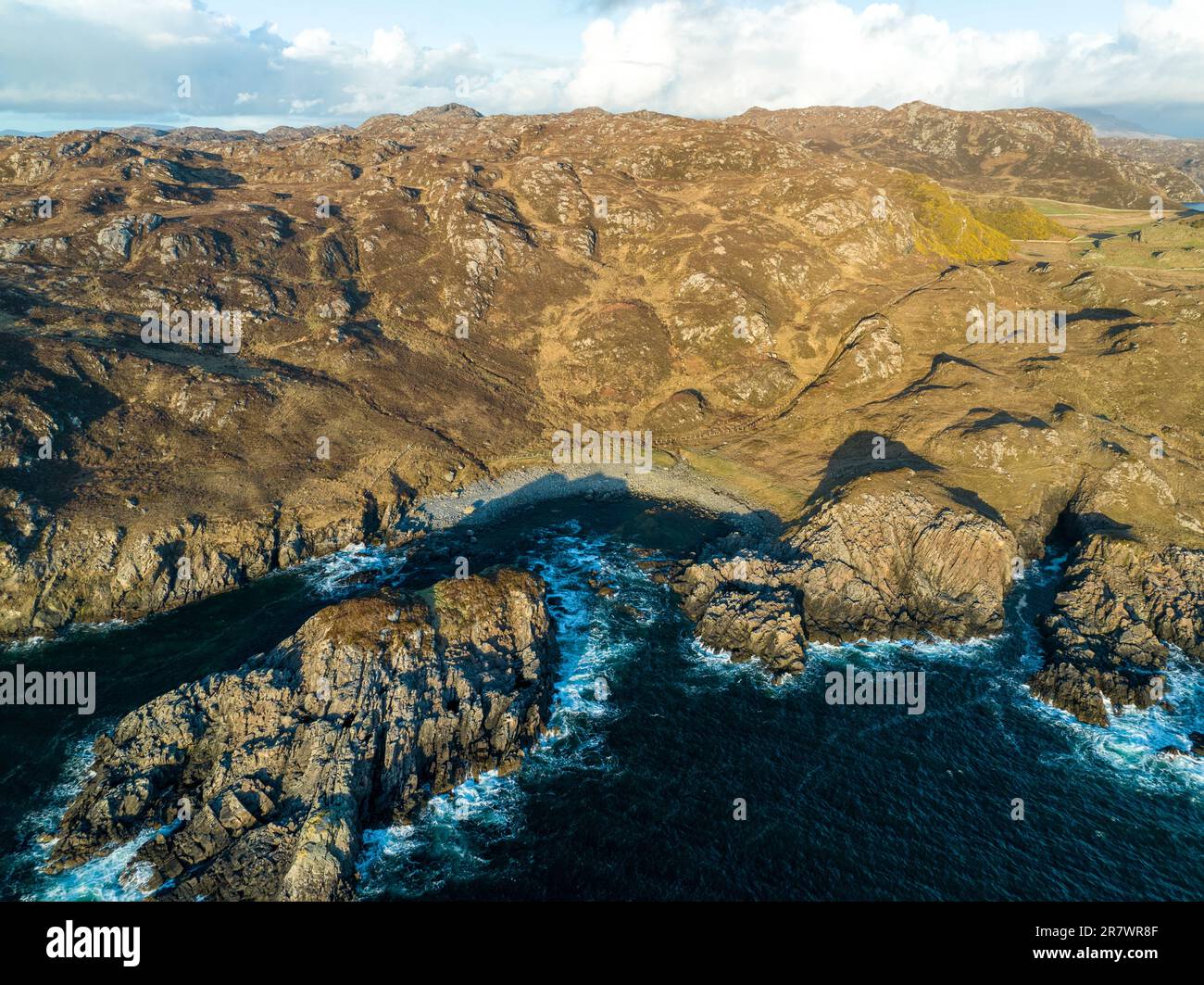 An expansive landscape of large rocks by a serene body of water Stock ...