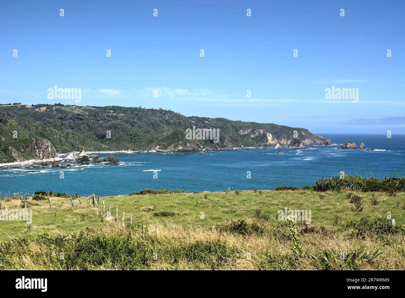 Beautiful seascape of overgrown coastal cliffs and ocean view on Chiloe ...