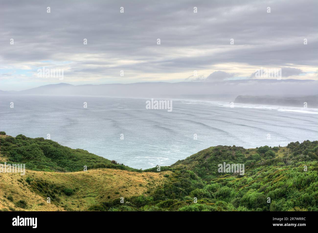 Beautiful seascape of overgrown coastal cliffs and ocean view on Chiloe ...