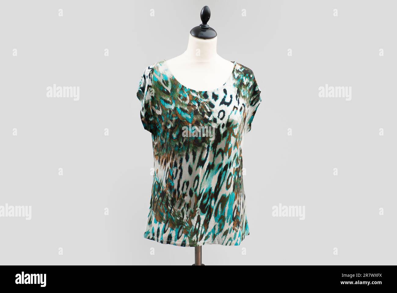 A White, green and blue leopard print short-sleeved top hangs on a ...