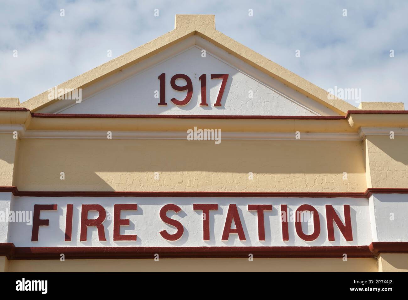Front of a building showing sign and year of completion. Overcast sky ...