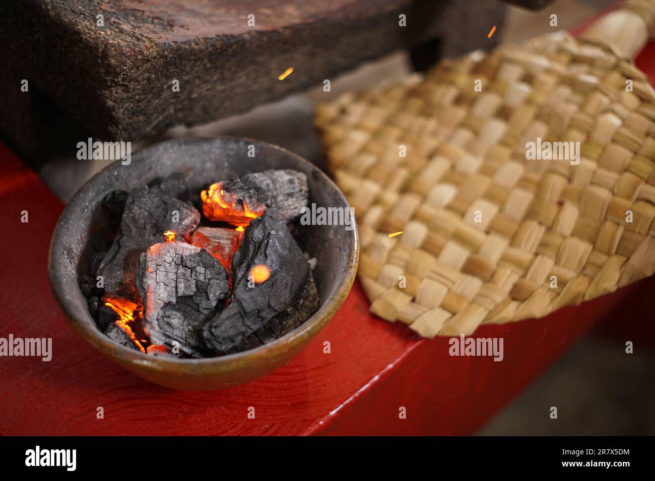 Hot burning charcoal to heat mayan grinding stone called metate Stock ...
