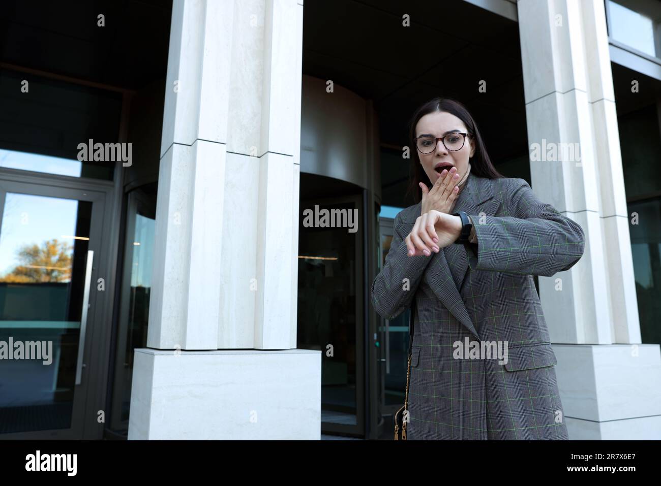 Emotional woman checking time on watch outdoors. Being late concept ...
