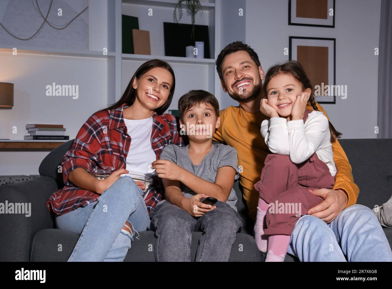 Happy family watching TV at home in evening Stock Photo - Alamy