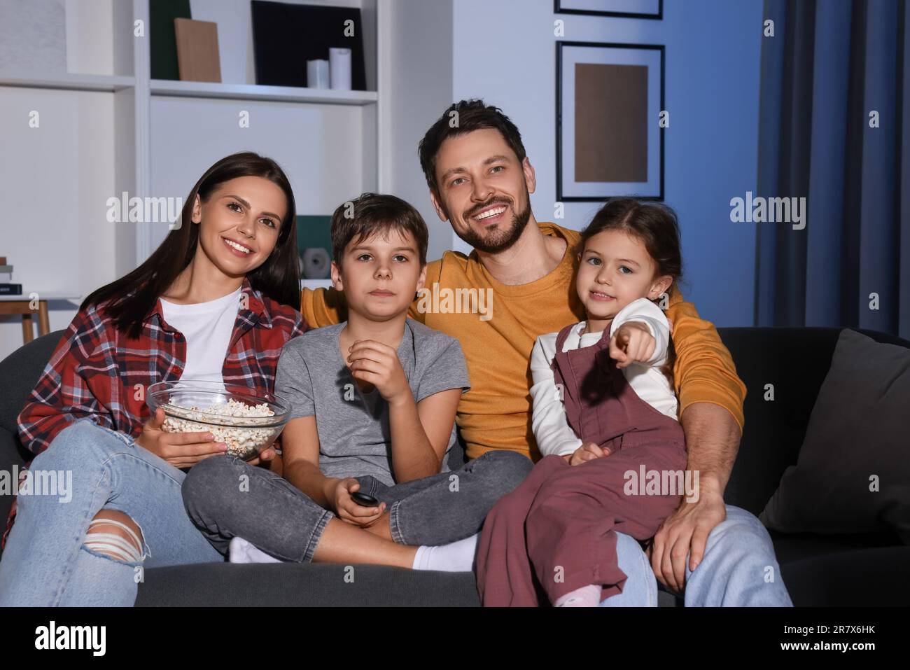Family watching TV at home in evening Stock Photo - Alamy