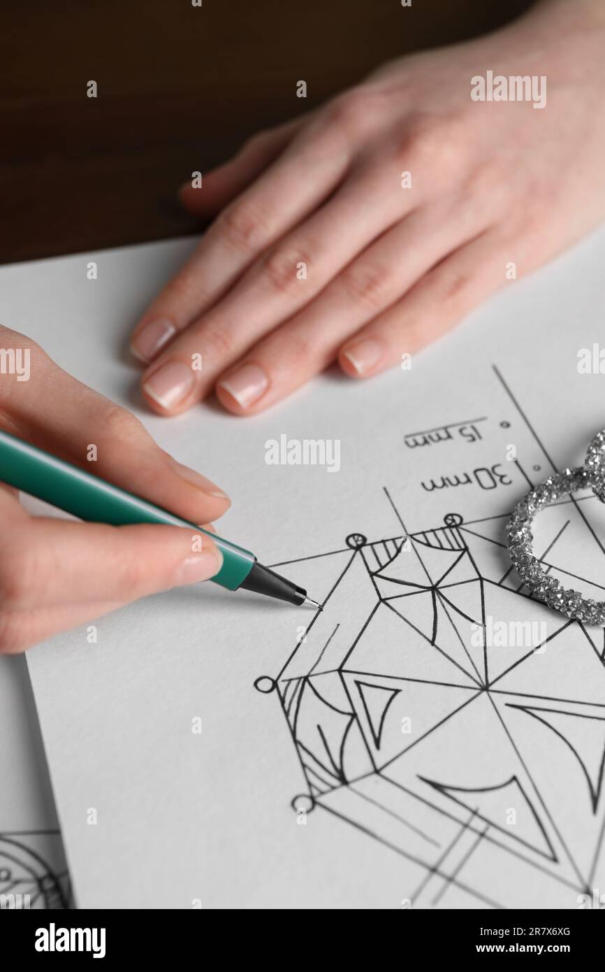 Jeweler drawing sketch of diamond on paper at table, closeup Stock ...