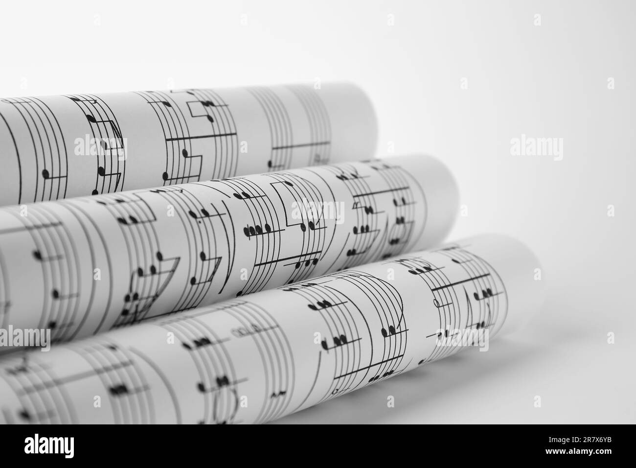 Rolled sheets with music notes on white background, closeup Stock Photo ...