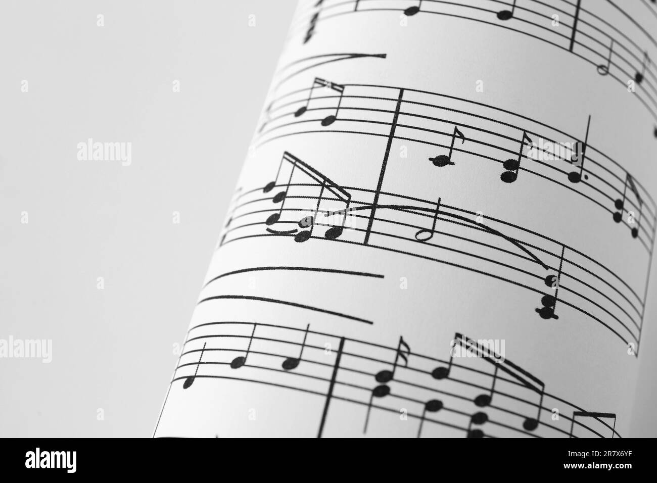 Rolled sheet with music notes on white background, closeup Stock Photo ...