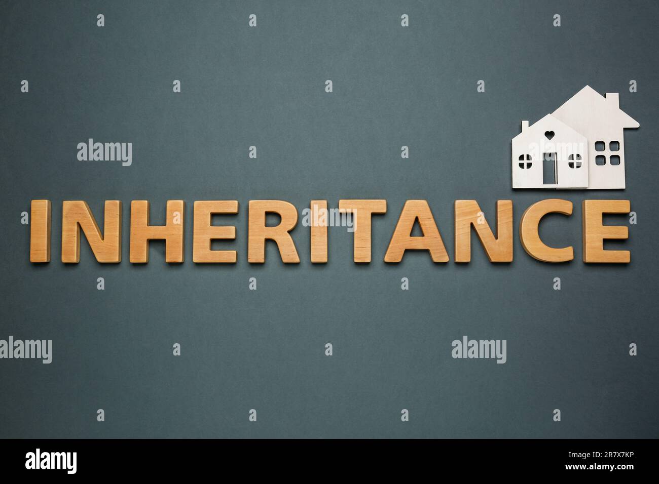 Word Inheritance made with wooden letters and houses model on black ...