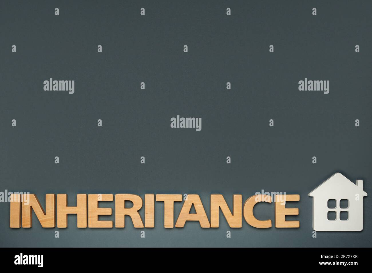 Word Inheritance made with wooden letters and house model on grey ...