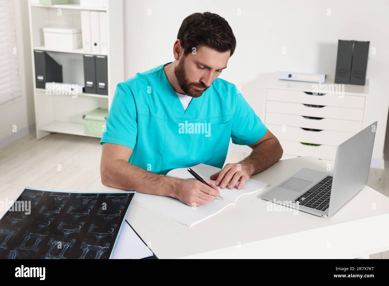 Doctor writing results from MRI scan in hospital Stock Photo - Alamy