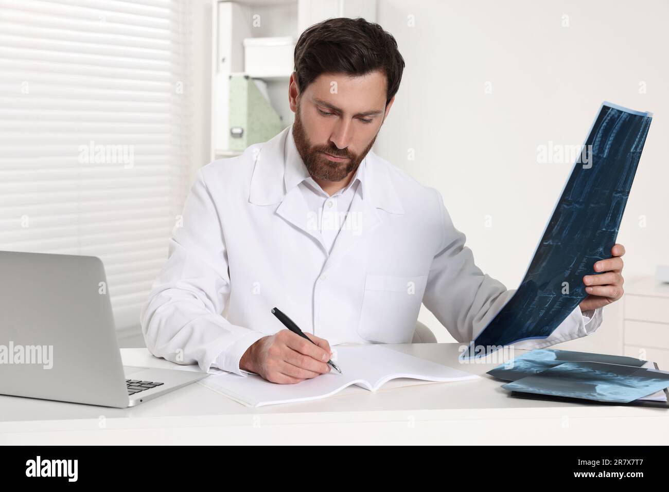 Doctor writing results from MRI scan in hospital Stock Photo - Alamy