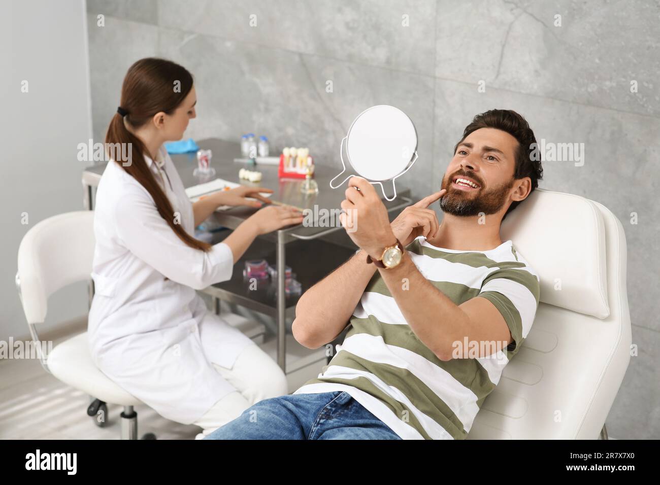 Man looking at his new dental implants in mirror indoors Stock Photo ...