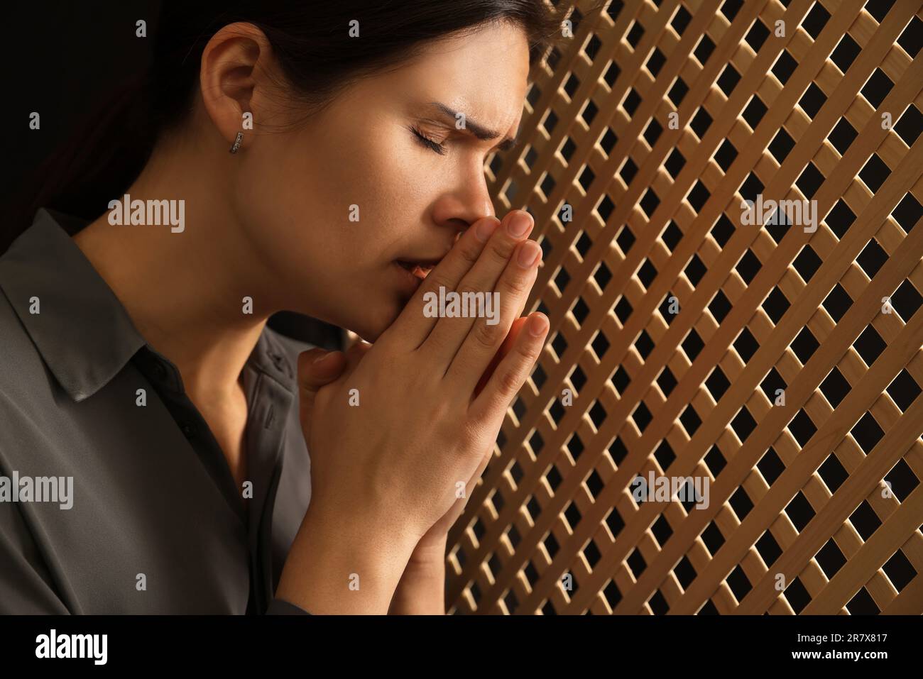 Woman praying to God during confession in booth Stock Photo - Alamy