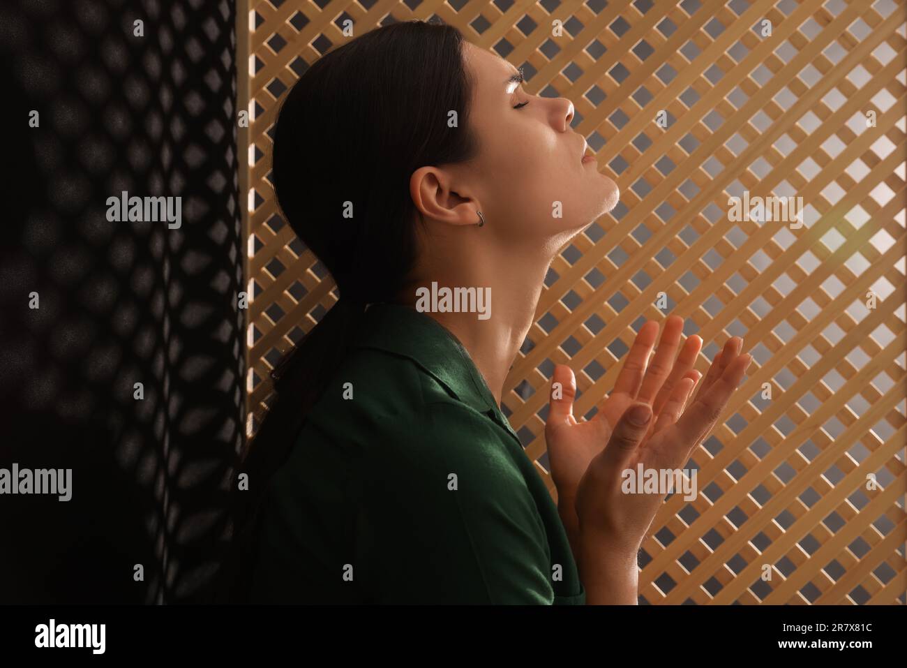 Woman praying to God during confession in booth Stock Photo - Alamy