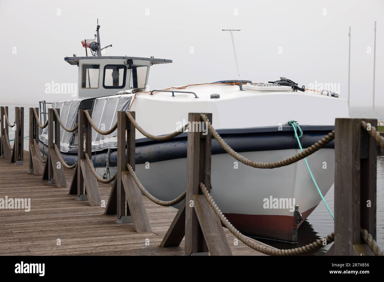 Picturesque view of moored boat behind pier fence Stock Photo - Alamy