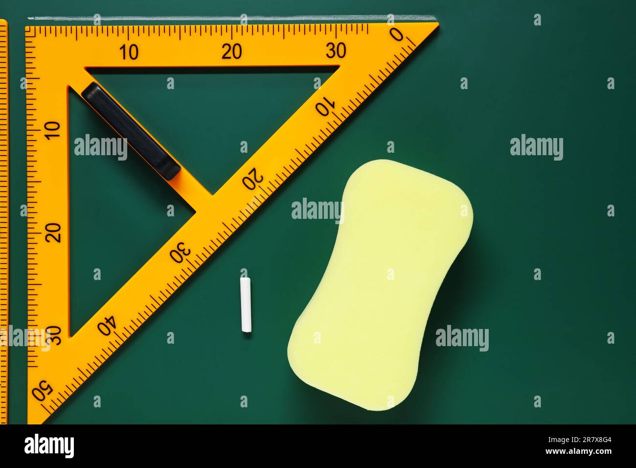 Protractor, sponge, chalk and ruler on green chalkboard, flat lay Stock ...