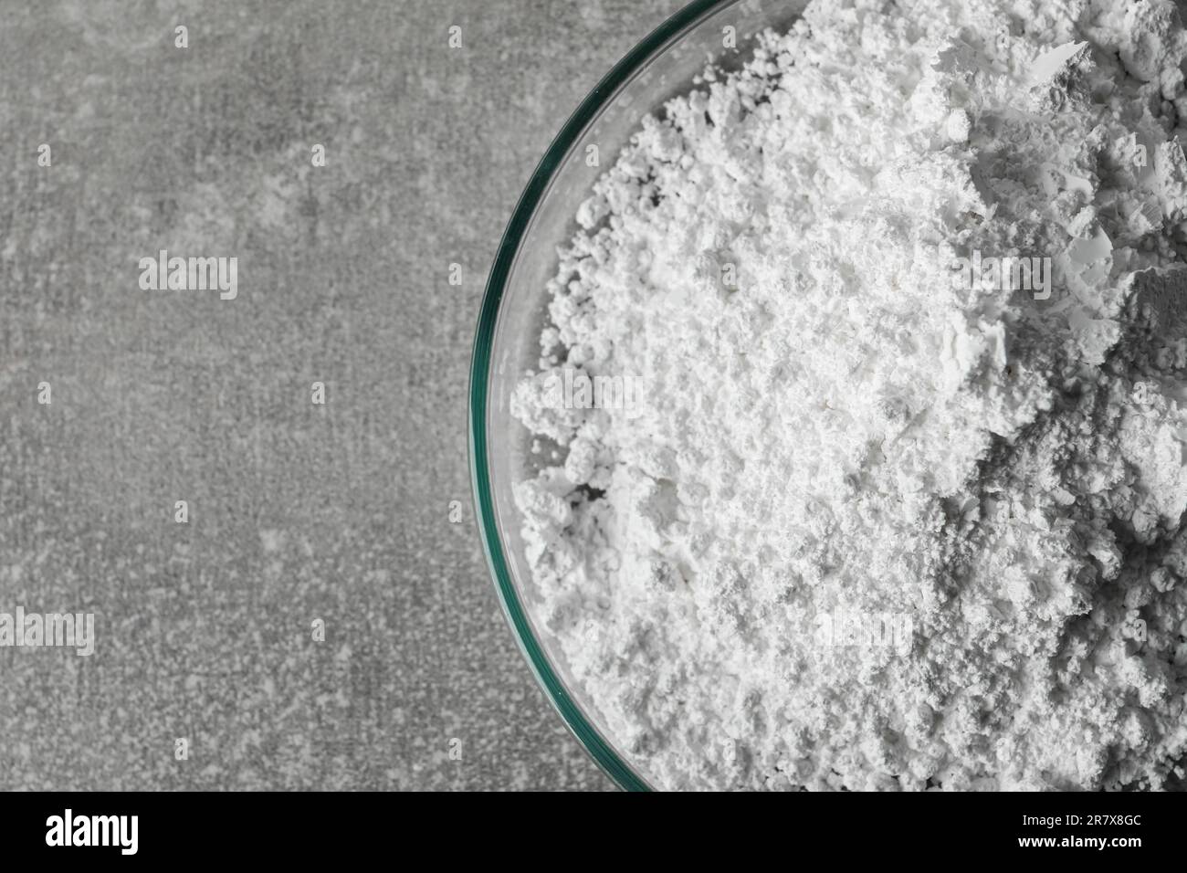 Petri dish with calcium carbonate powder on light grey table, closeup ...