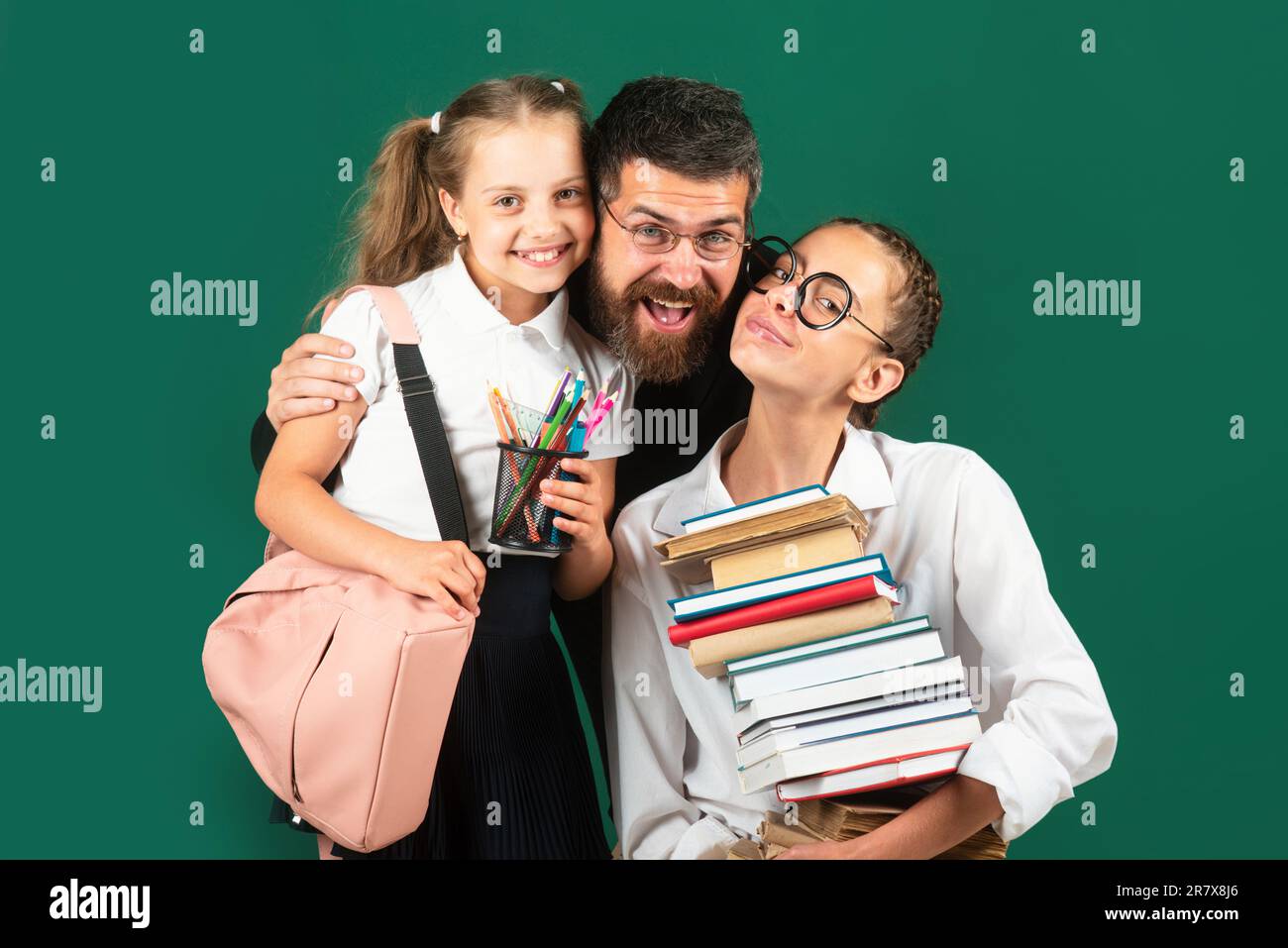 Portrait of father and school kids daughters hugging on blackboard ...