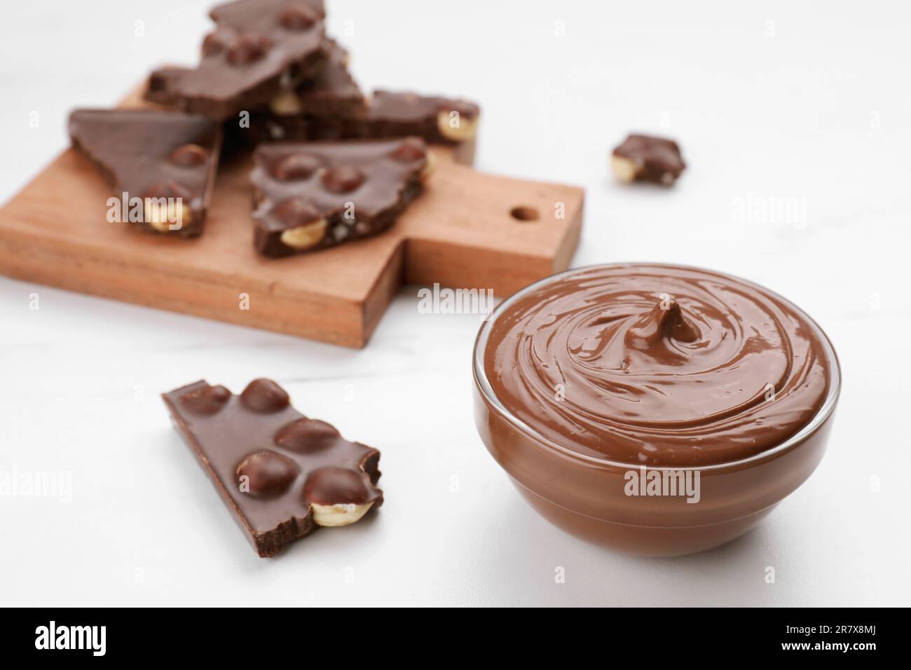 Pieces of tasty chocolate and sweet paste on white table, closeup Stock ...
