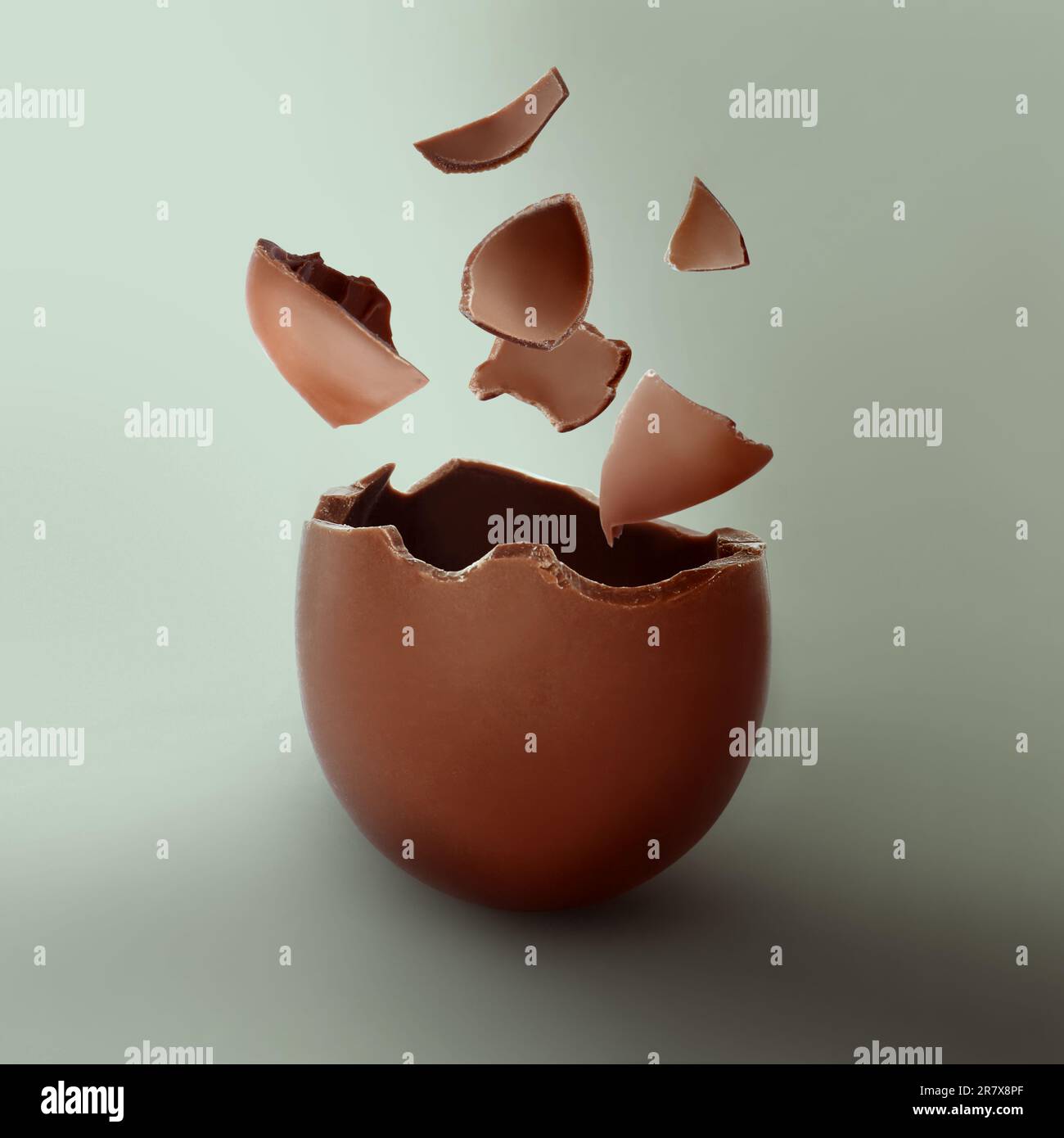 Exploded milk chocolate egg on color background Stock Photo - Alamy