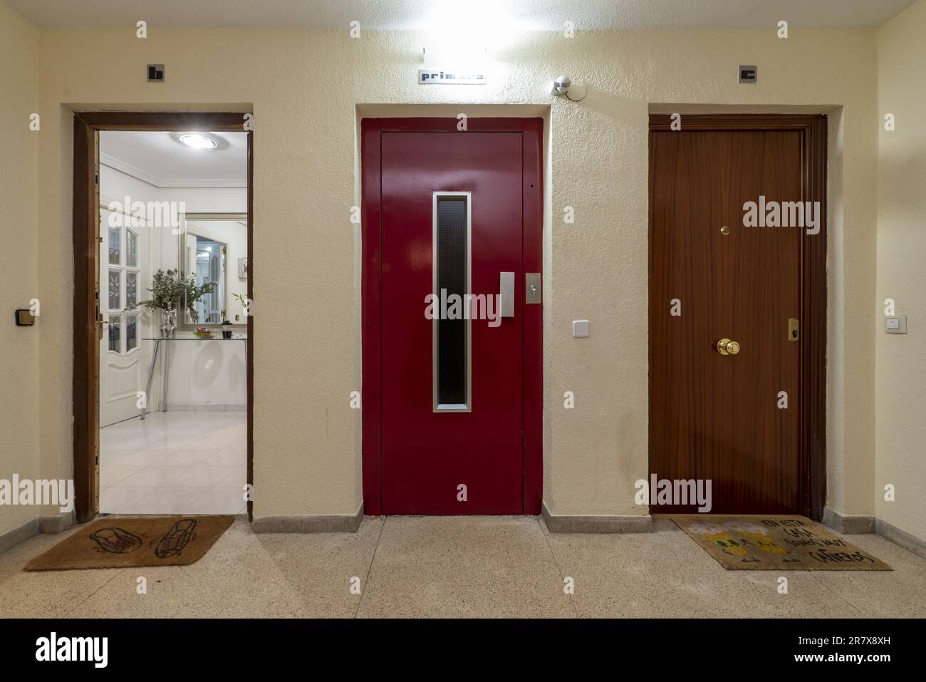 Landing of a house with an elevator with a red door and an open access ...