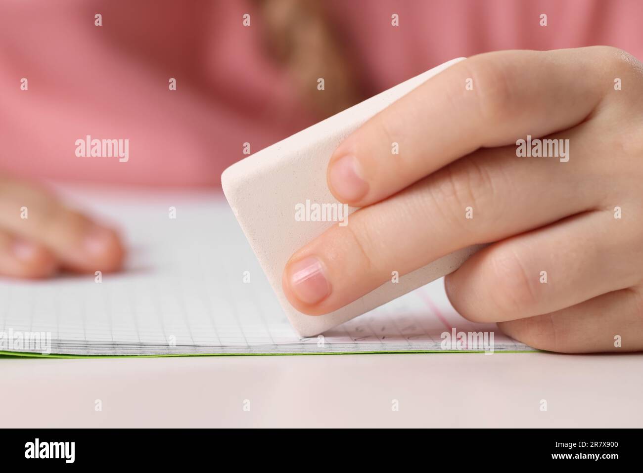 Girl using eraser at white desk, closeup Stock Photo - Alamy