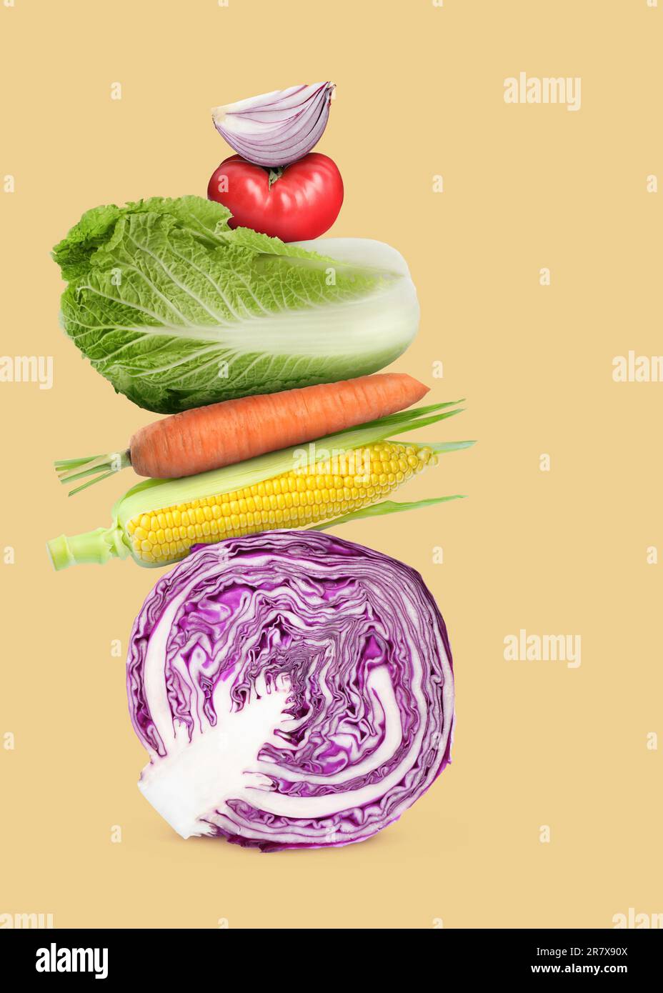 Stack of different fresh vegetables on light gold background Stock ...